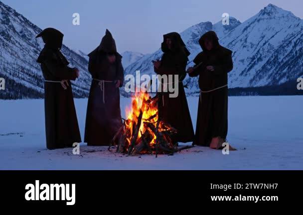 Group of monks in brown cloaks of the order of St. Francis are warming ...