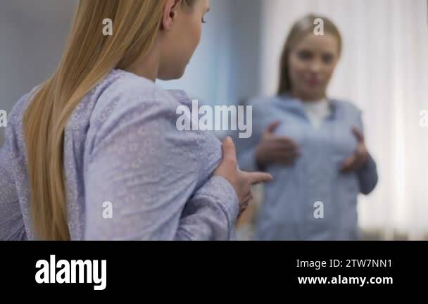 Teen girl choosing poses for good looking appearance in room mirror ...