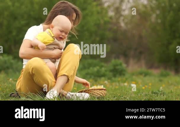 Angry baby in the arms of her mother. The baby is crying, mom calms ...
