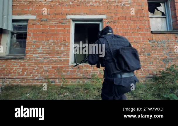 Two SWAT solders jump run and jump inside a rundown building Stock ...