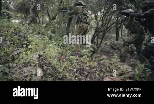 Squad of fully armed commando soldiers during combat in a forest ...