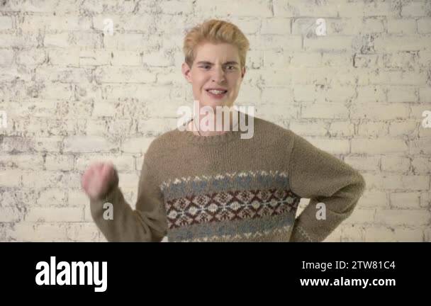 A young guy with blond hair is angry, nervous and claps his hands ...
