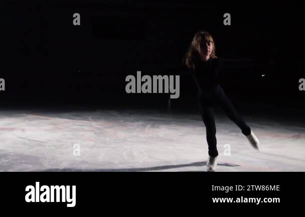 A beautiful figure in a black suit makes a rotation around her axis in ...