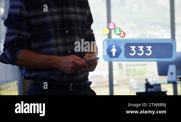 Close up of a Caucasian employee texting in the office. Beside him is a ...