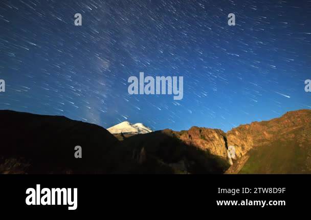 stars draw fading lines over Mount Elbrus. Night landscape. Russia ...