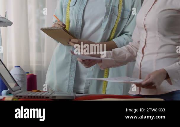 Dressmakers correcting drawings of prom dress collection, working on ...