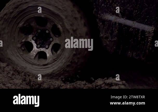 Wheel in the Mud. SUV wheel slips in the mud, but moves slowly Stock ...