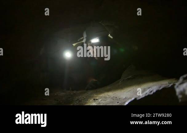 Two young hikers explorers stuck in the narrow hole in dark cave Stock ...