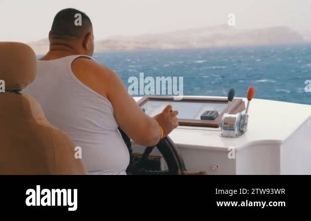 Fat Captain Controls the Tourist Yacht in Sea Storm. Steering Wheel of ...