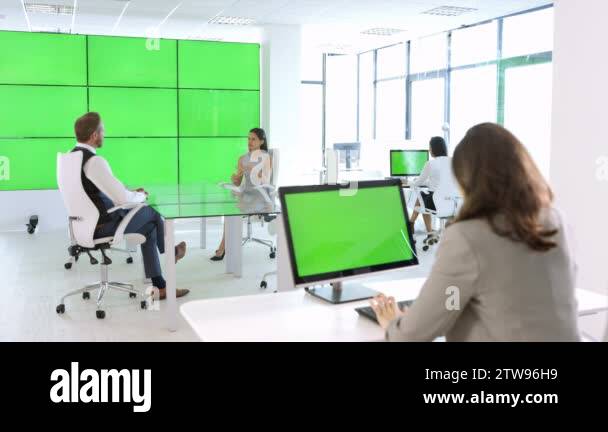 4K Business team in modern office green screen on video wall and ...