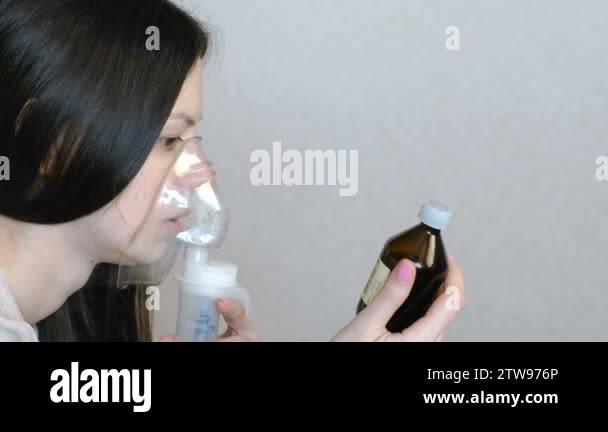 Use nebulizer and inhaler for the treatment. Closeup womans face ...