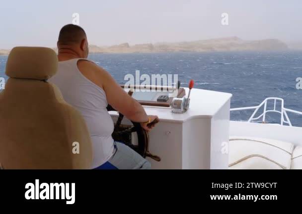 Fat Captain Controls the Tourist Yacht in Sea Storm. Steering Wheel of ...