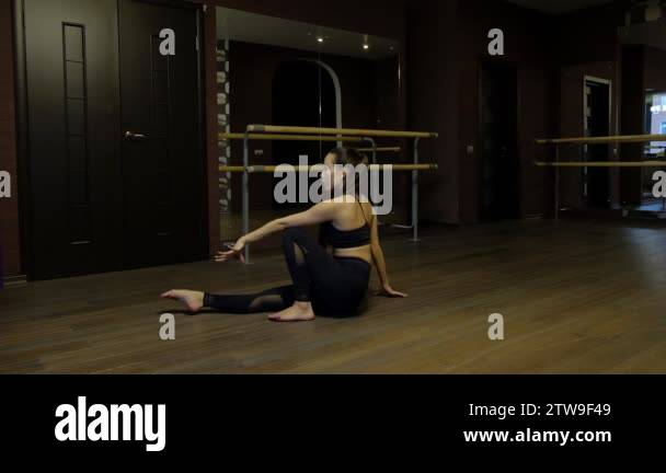 girl dancer with ponytail in black tights demonstrates body flexibility ...