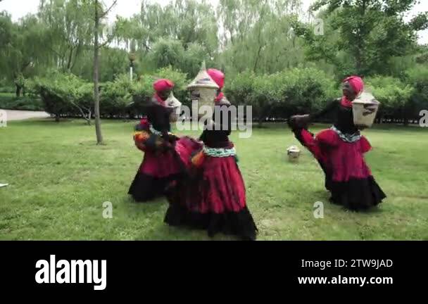 Three african women dancing a folk dance in traditional costumes with ...