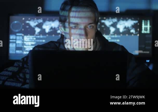 Male Hacker Programmer Working At Computer While Blue Code Characters