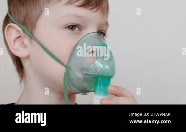 Use nebulizer and inhaler for the treatment. Boy inhaling through ...