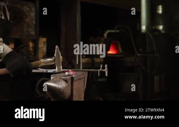 Blacksmith is beating by large hammer on metal detail over anvil Stock ...