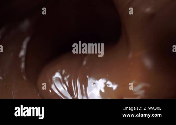 Food macro video with texture of pouring liquid milk chocolate, melted ...