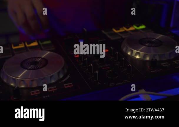 DJ control music console and colorful light in nightclub. DJ mixer ...