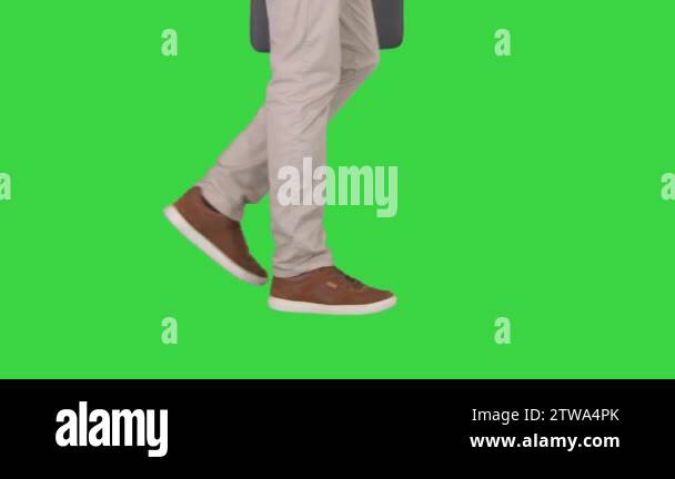 Mans feet is walking in jeans and sneakers on a Green Screen, Chroma ...