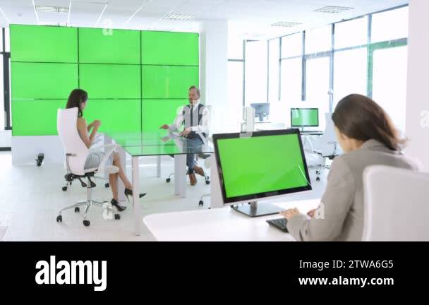 4K Business team in modern office green screen on video wall and ...