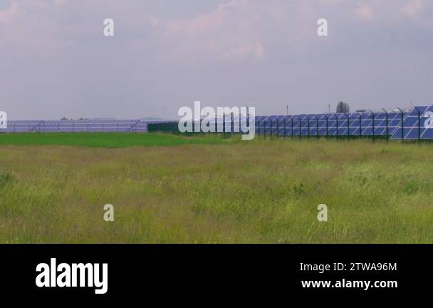 Solar park with cell panels generating green energy against grass field ...