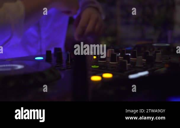 Male hand disk jockey on mixing console for mixing techo music on disco ...