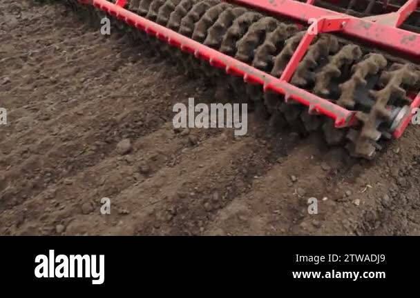 close-up, tractor cultivator cultivates, digs the soil. tractor plows ...