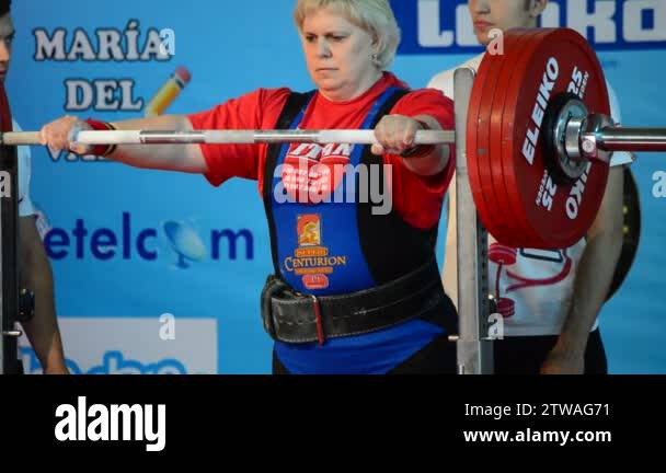Woman weightlifter in a powerlifting competition performing squat test ...