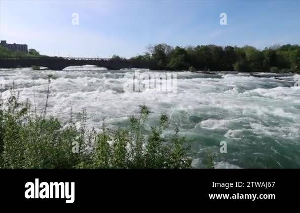 Handheld panning view of rushing water rapids on Niagara River before ...