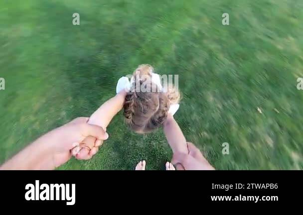 Father holding hands daughter and whirl around himself. Having fun ...