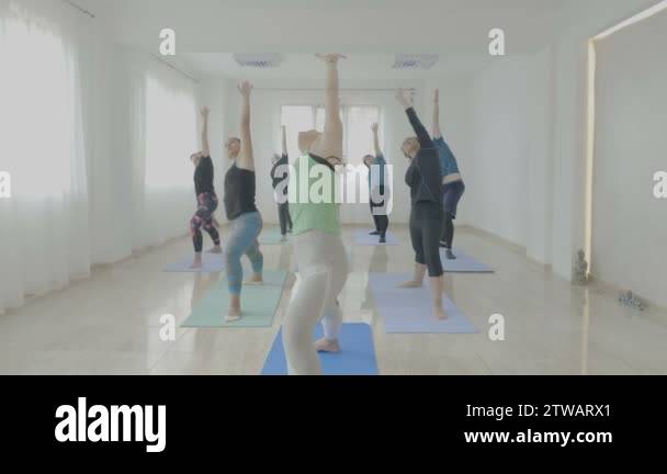 Women learning warrior pose during a yoga class as therapy to recover ...