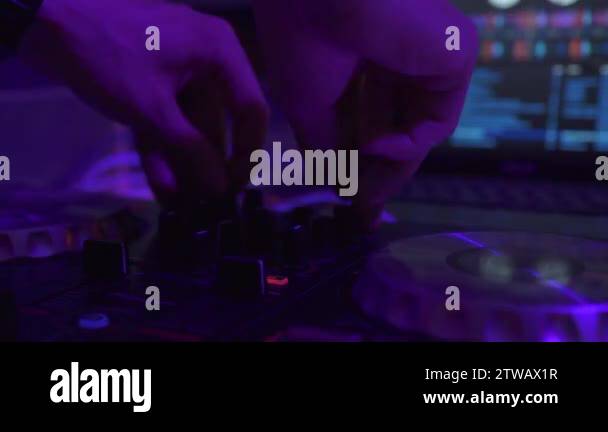 DJ control music console and colorful light in nightclub. DJ mixer ...
