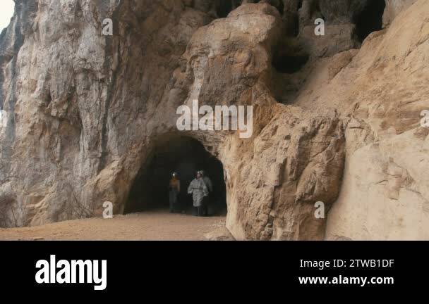 Young explorers in helmets coming out from the large dark cave Stock ...