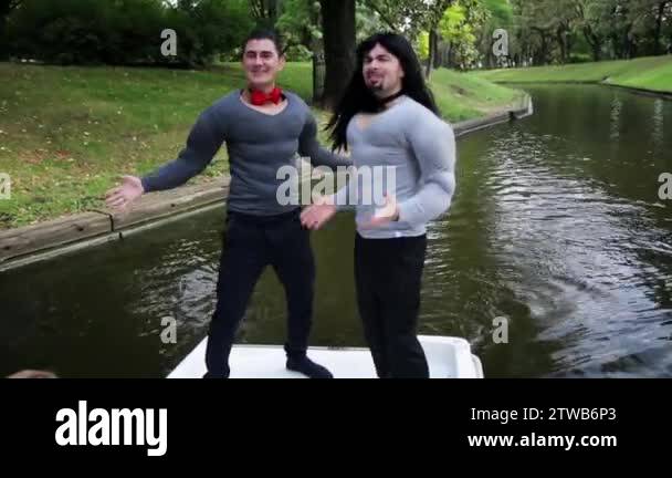 Two good-looking funny men dressed in fake muscle costumes are singing ...