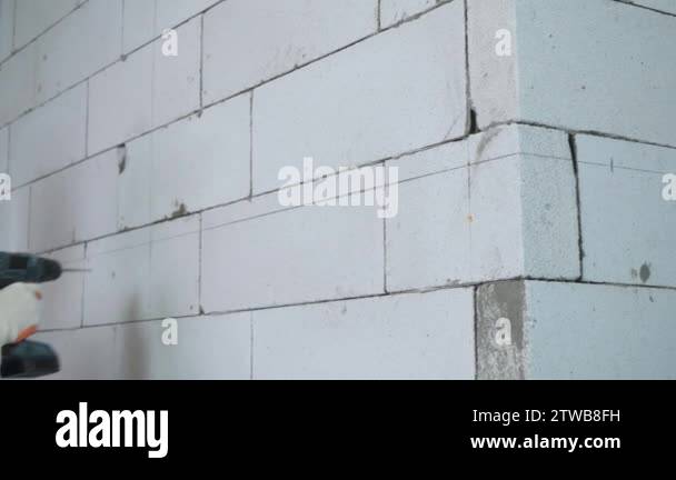 builder drilling holes in block wall and inserting dowels Stock Video ...