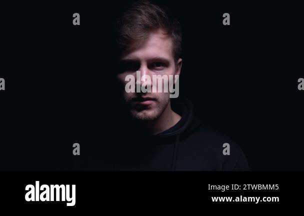 Dangerous man with crazy grin looking into camera maniac against dark ...