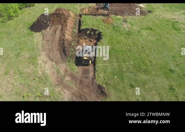aerial of two excavators dig foundation pit for new house according to ...