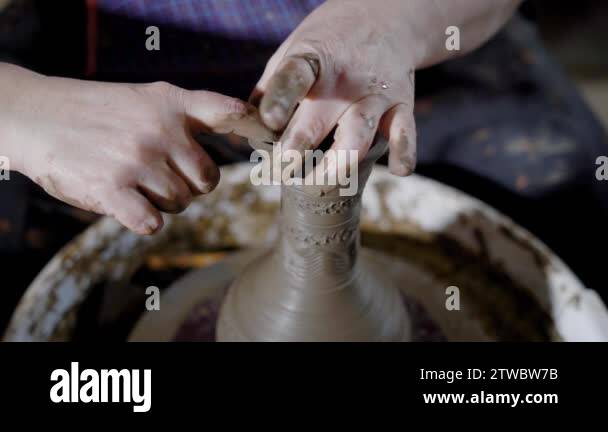 Crop talented hands of artisan creating earthenware on potters wheel in ...