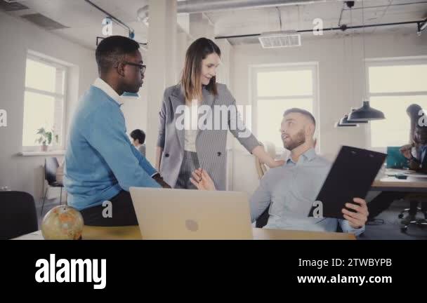 Beautiful female CEO discussing work process with young multiethnic ...