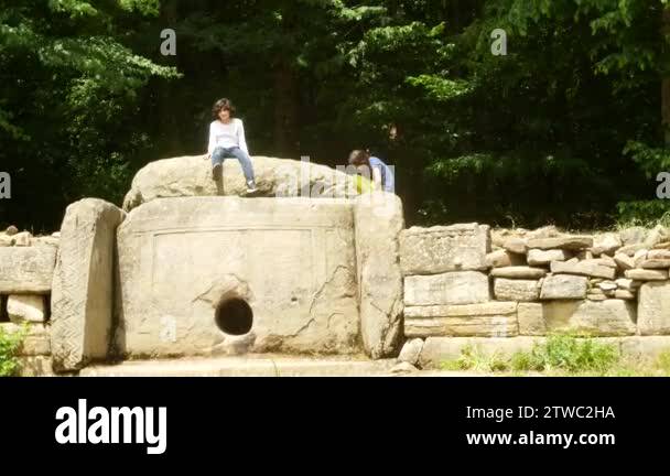 tourists, exploring the ancient dolmen, take photos on the phone for ...