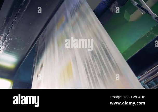 Two views of a whole massif of printed paper sheets getting processed ...