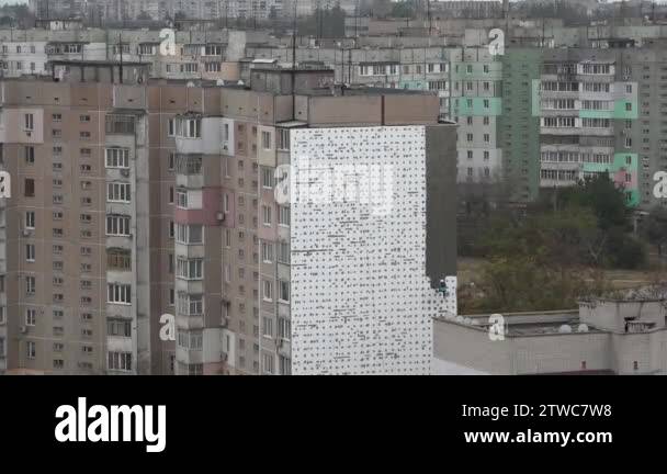 High-altitude work. The man works on high-rise works cladding ...
