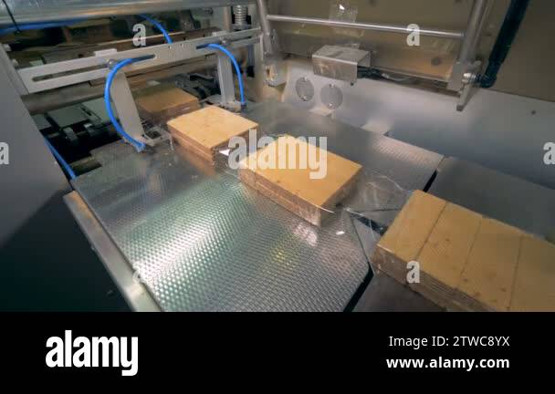 Whole line of plastic wrap with waffles in it is getting cut and sealed ...