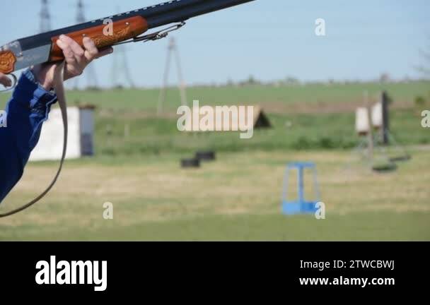 Hunter is training on a skeet range with his shortgun in summer in slow ...