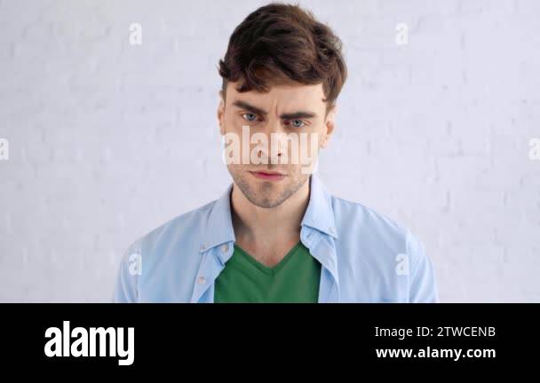 young aggressive man looking at camera, screaming and showing middle ...
