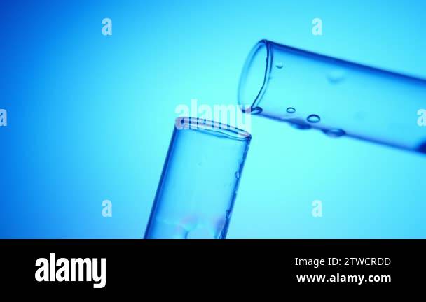 Sparkling fluid flows from one test tube into another in a medical ...