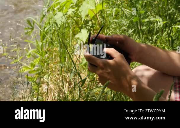 Close-up guys hands using remote control with drone mounted camera ...