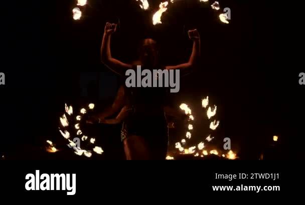 Three women with burning hoops dance with fiery torches in leather ...