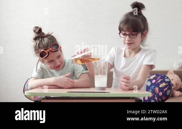 funny children conduct a chemical experiment and mix reagents. kids are ...